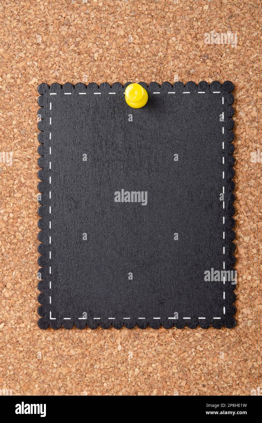 Vertical blank blackboard with push pin on wooden wall for your text or ...