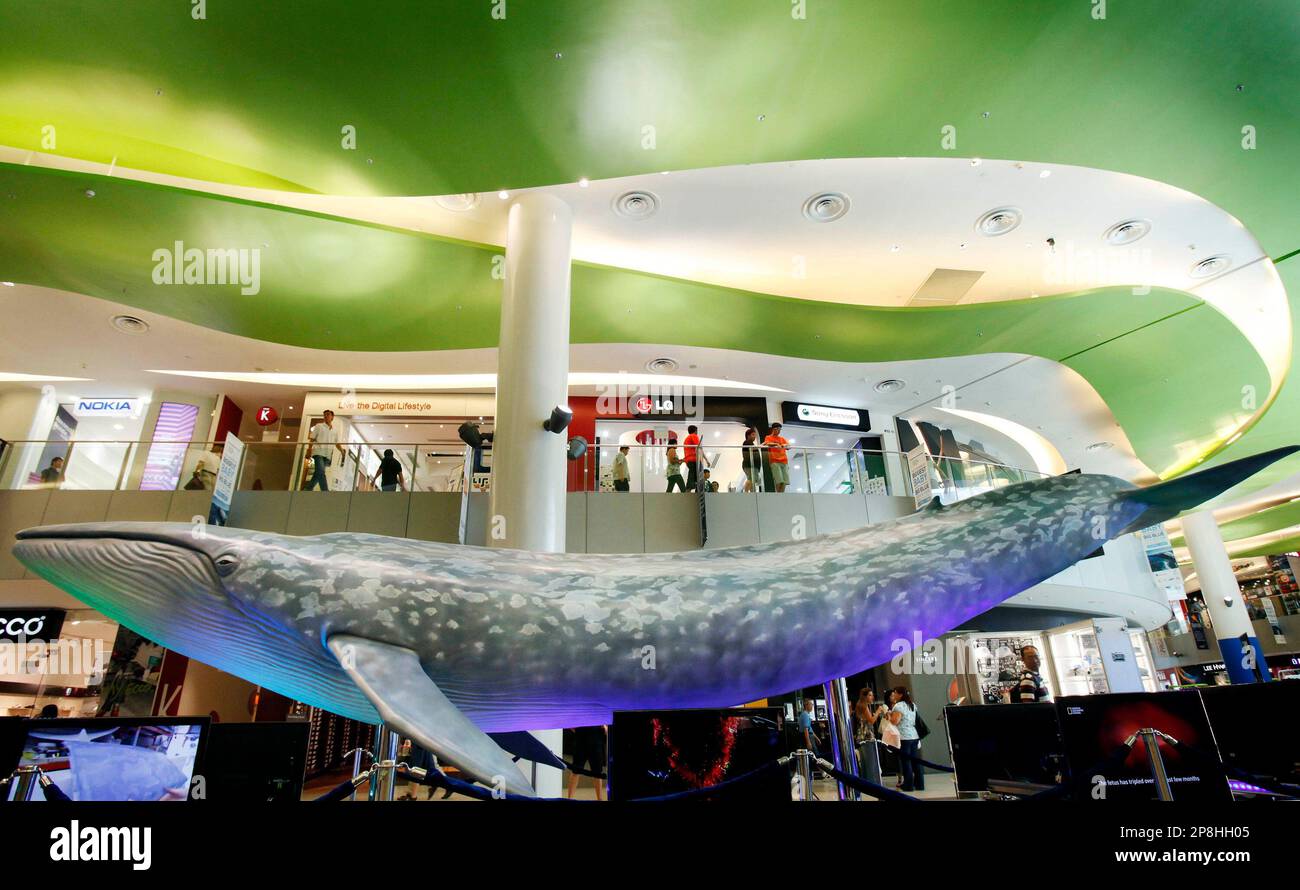 Shoppers walk around a shopping mall where a full-scaled model of a ...