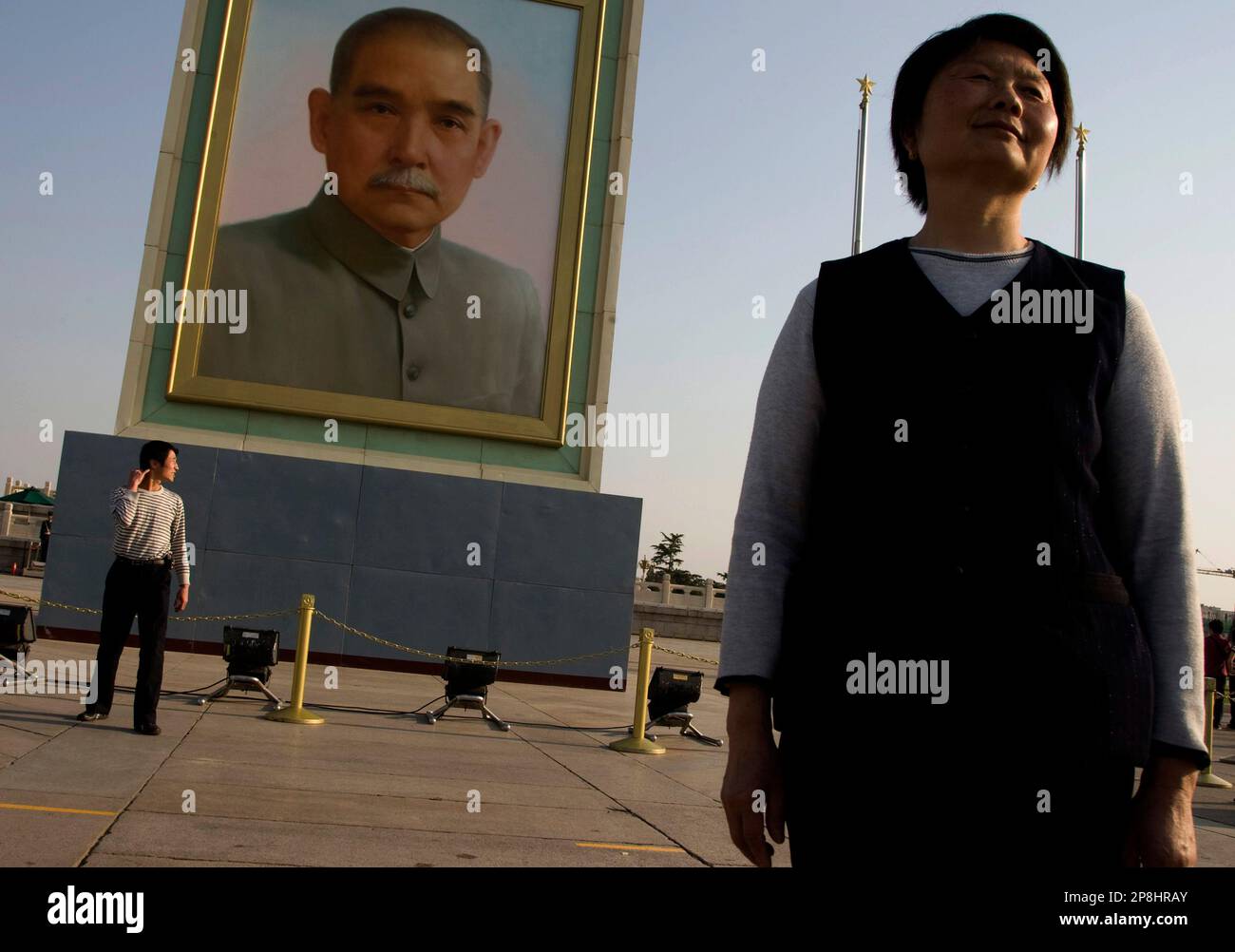 Chinese visitors to Tiananmen Square pose near a portrait of the ...
