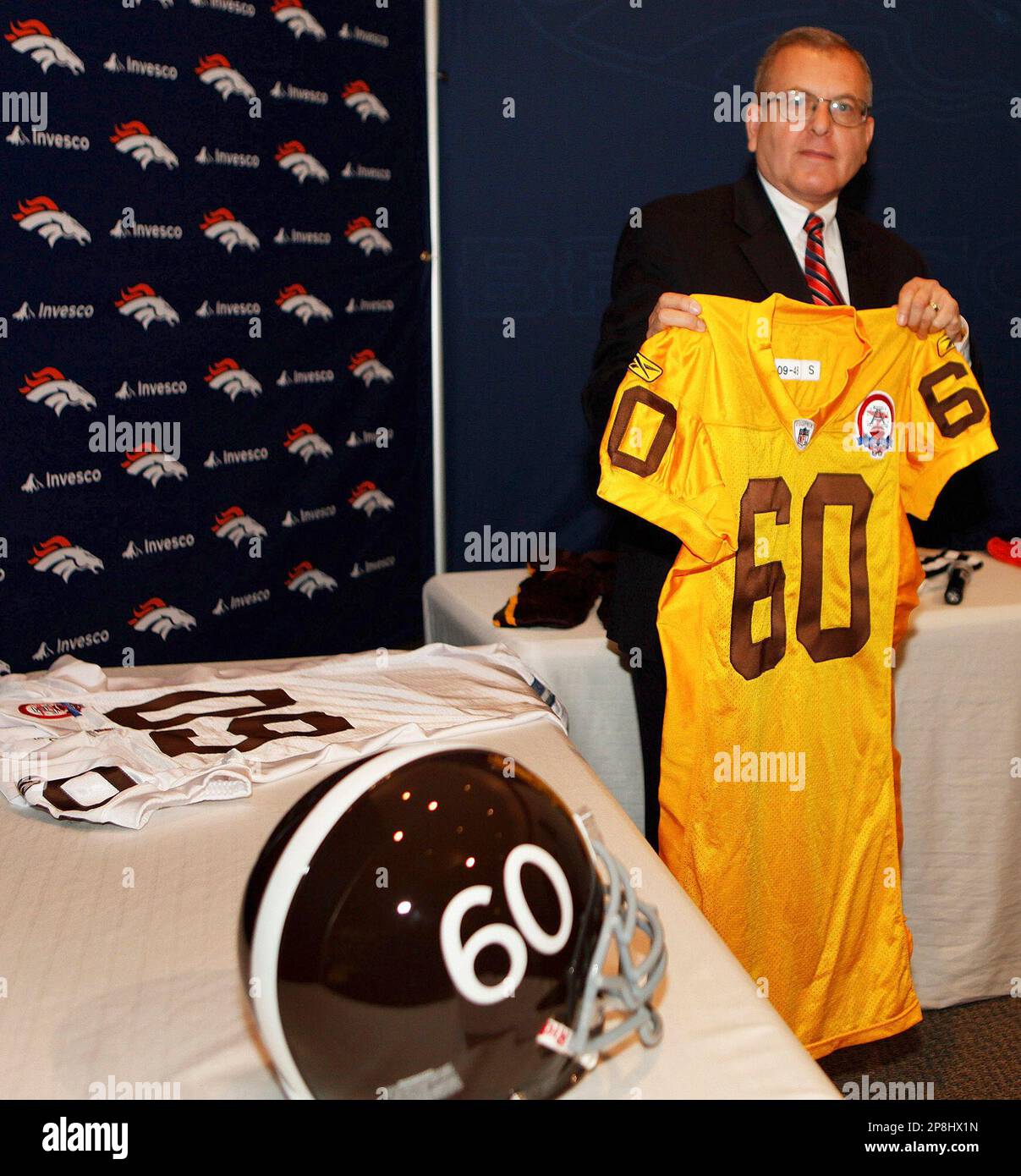 Denver Broncos' vice president Jim Saccomano holds a 1960's team ...