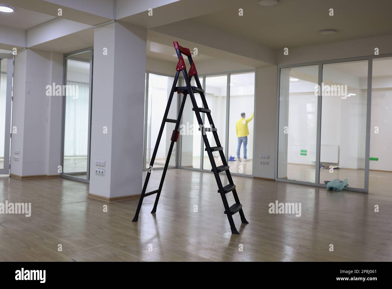 High ladder standing in center of empty office Stock Photo - Alamy