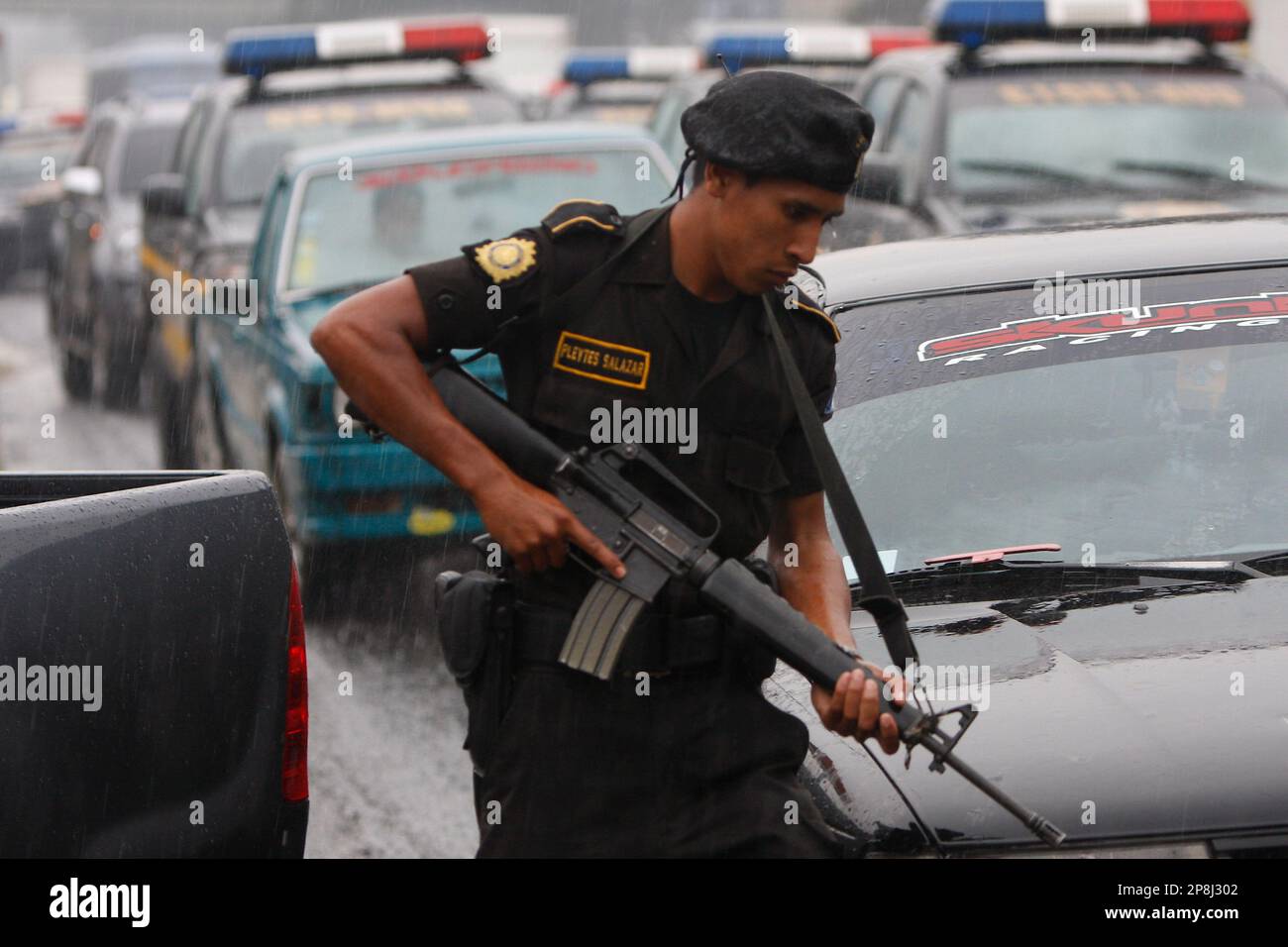 Under pouring rain, a police officer patrols after a shooting between ...