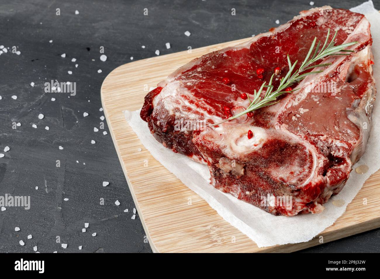 Raw fresh meat t-bone steak with spices on a dark background Stock ...