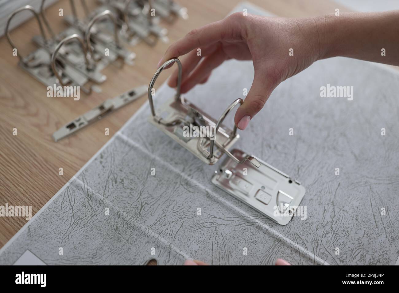 Secretary attaching metal bindings to office folders Stock Photo - Alamy