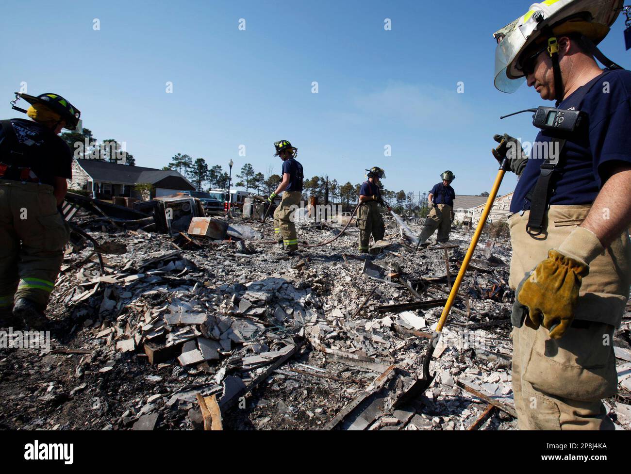 Firefighters with the Sumter Fire Department work to put out hot spots ...