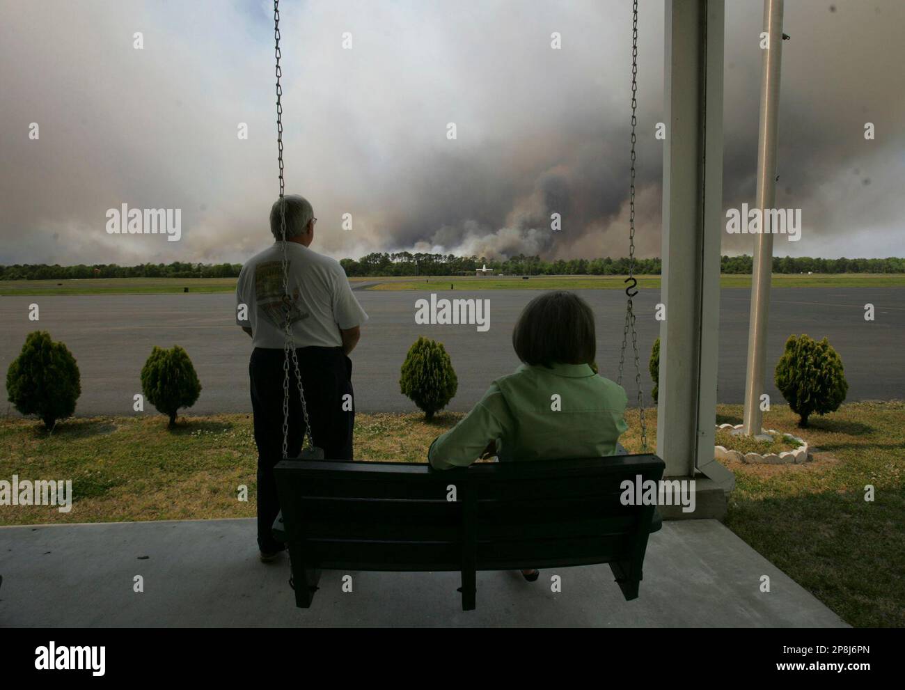 Evacuees Larry and Janet Stewart watch the smoke billow from the ...