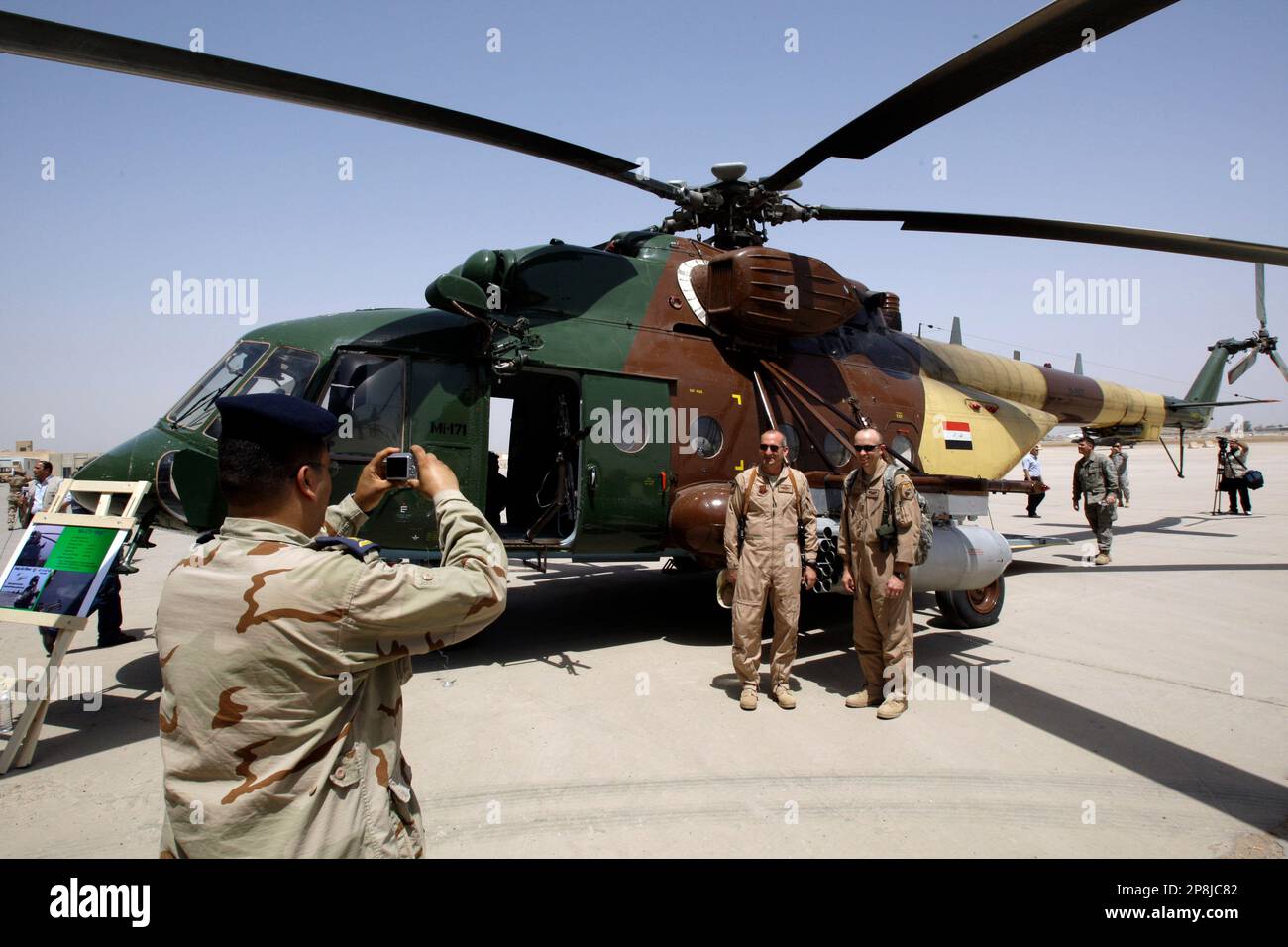 An Iraqi military officer takes a picture of two U.S. military ...