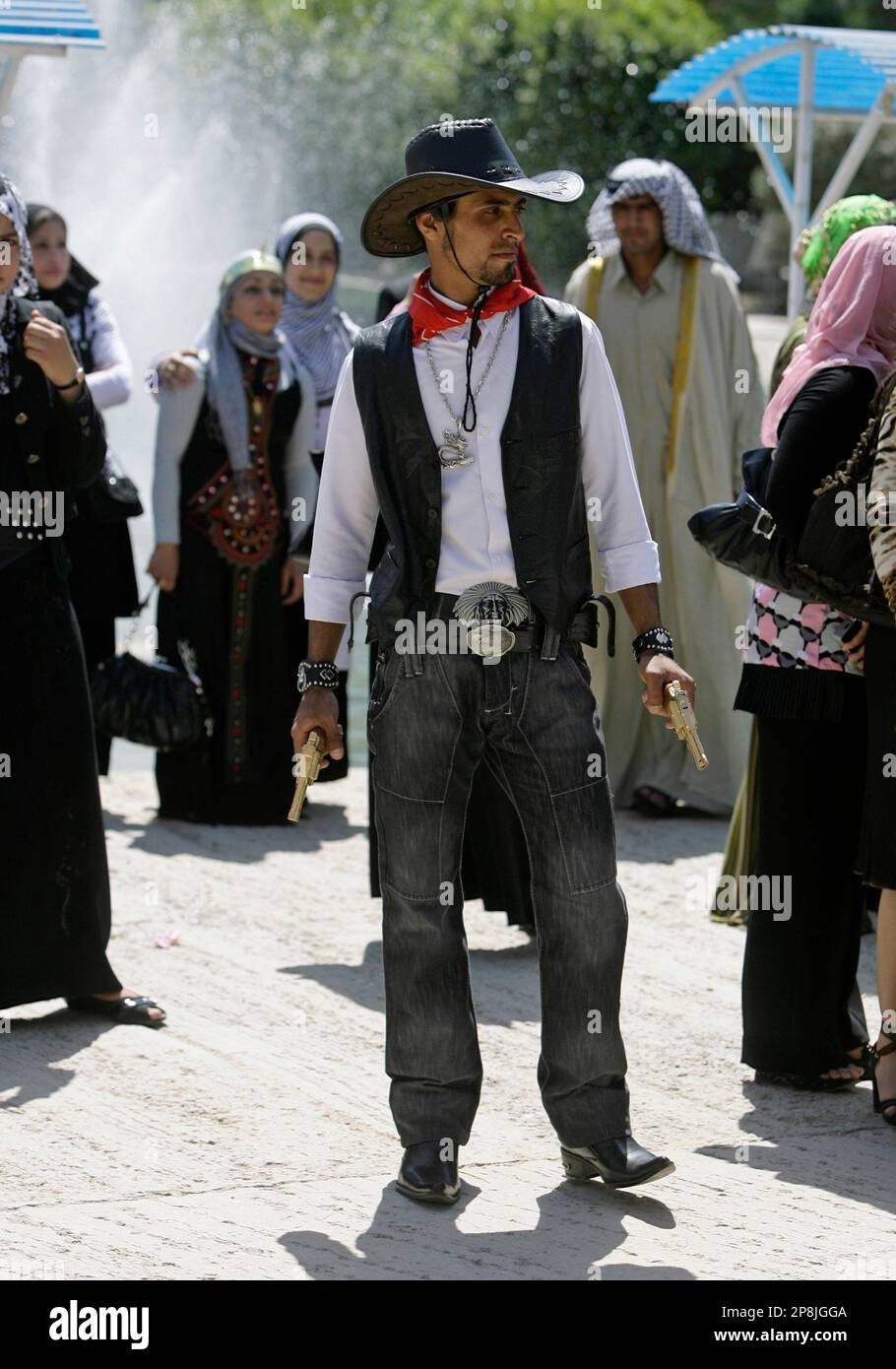 A Baghdad University student wears a cowboy costume at an open air ...