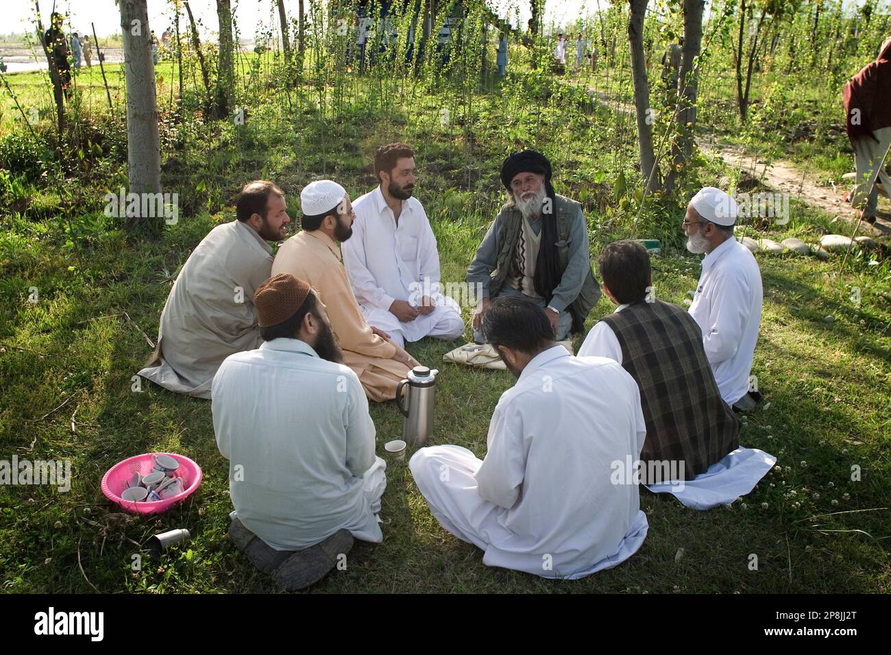 Taliban spokesman Muslim Khan, center wearing a black turban, talks to ...