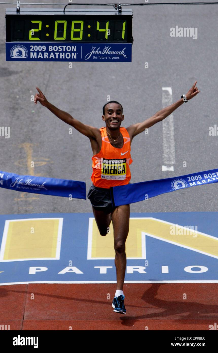 Deriba Merga of Ethiopia raises his arms as he breaks the tape to win ...