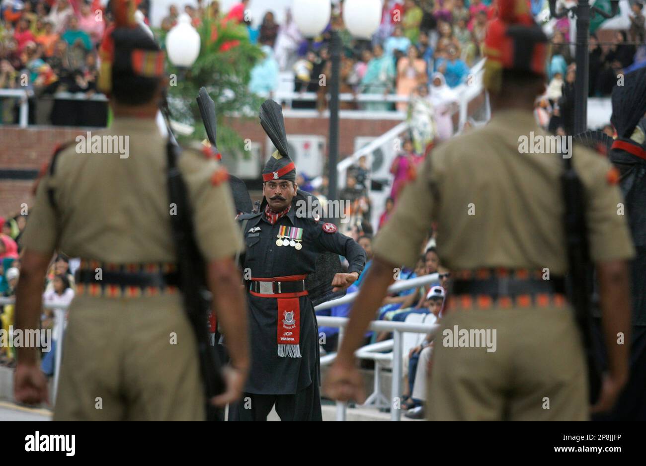 A Pakistani Border Guard, in black, gestures as he looks towards Indian ...