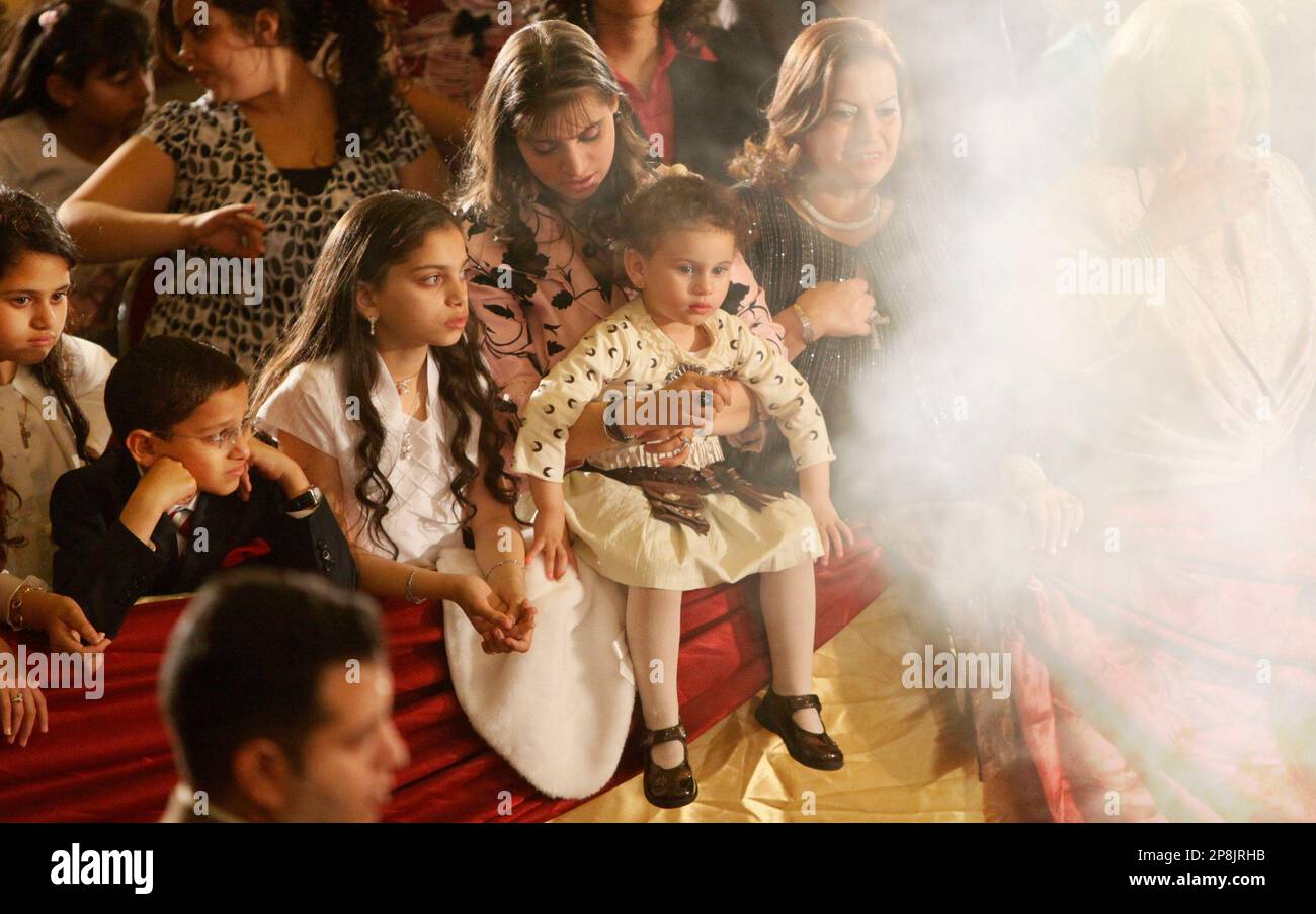 Coptic children look on as Coptic priests, unseen, waft a cloud of ...