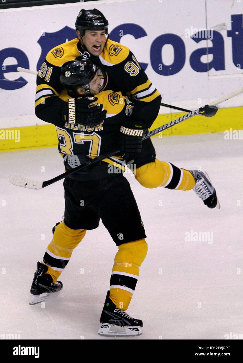 Boston Bruins center Marc Savard (91) leaps into the arms of teammate ...