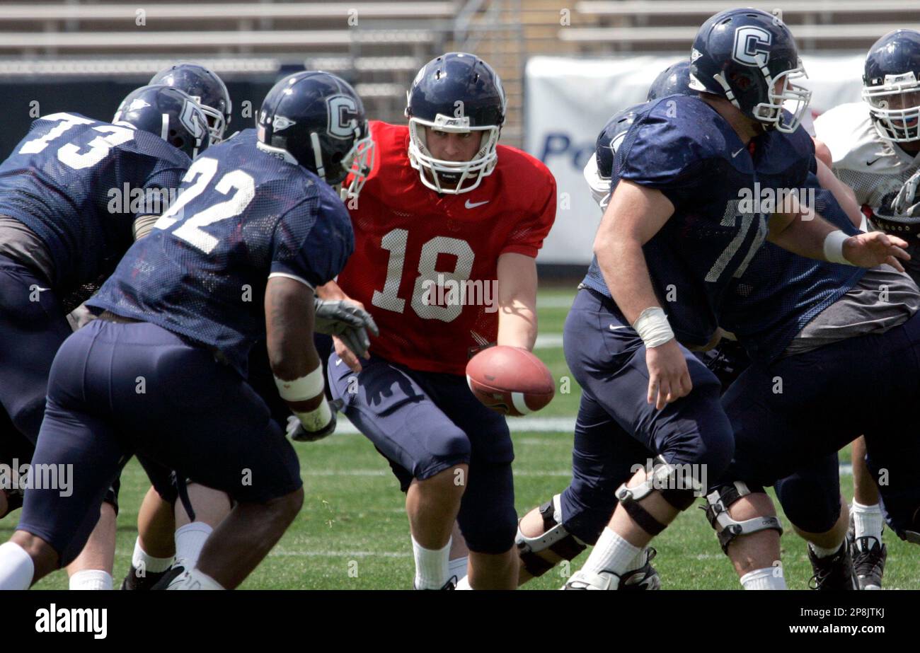 Connecticut quarterback Johnny McEntee hands off to Wylie ...