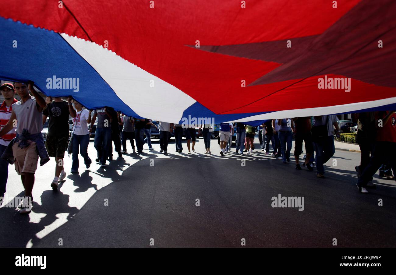 Students hold a Cuban flag during a march to mark the 48th anniversary ...