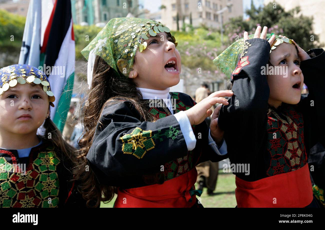 Palestinian girls react as they watch the release of balloons during ...