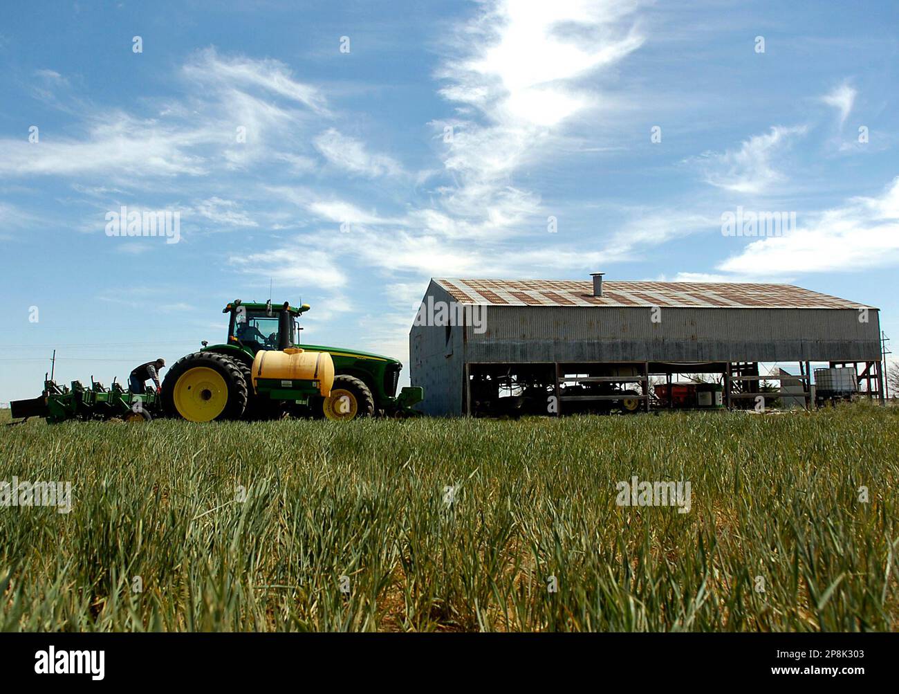 Glen Martin, left, and John Dyke, connect an eight-row lister to a ...