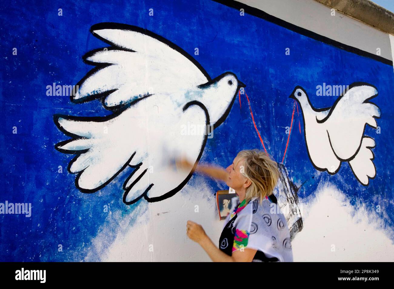 German artist Rosemarie Schnitzler paints a picture at the East Side ...