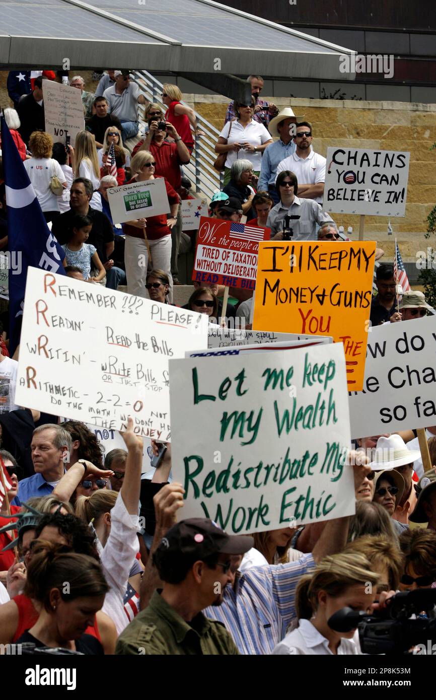 The crowd displays signs during a "Don't Mess With Texas" tea party ...