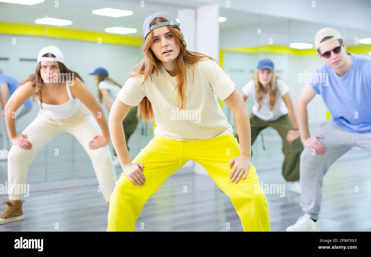 Young girl in cap training breakdance Toprock moves in dance hall Stock ...