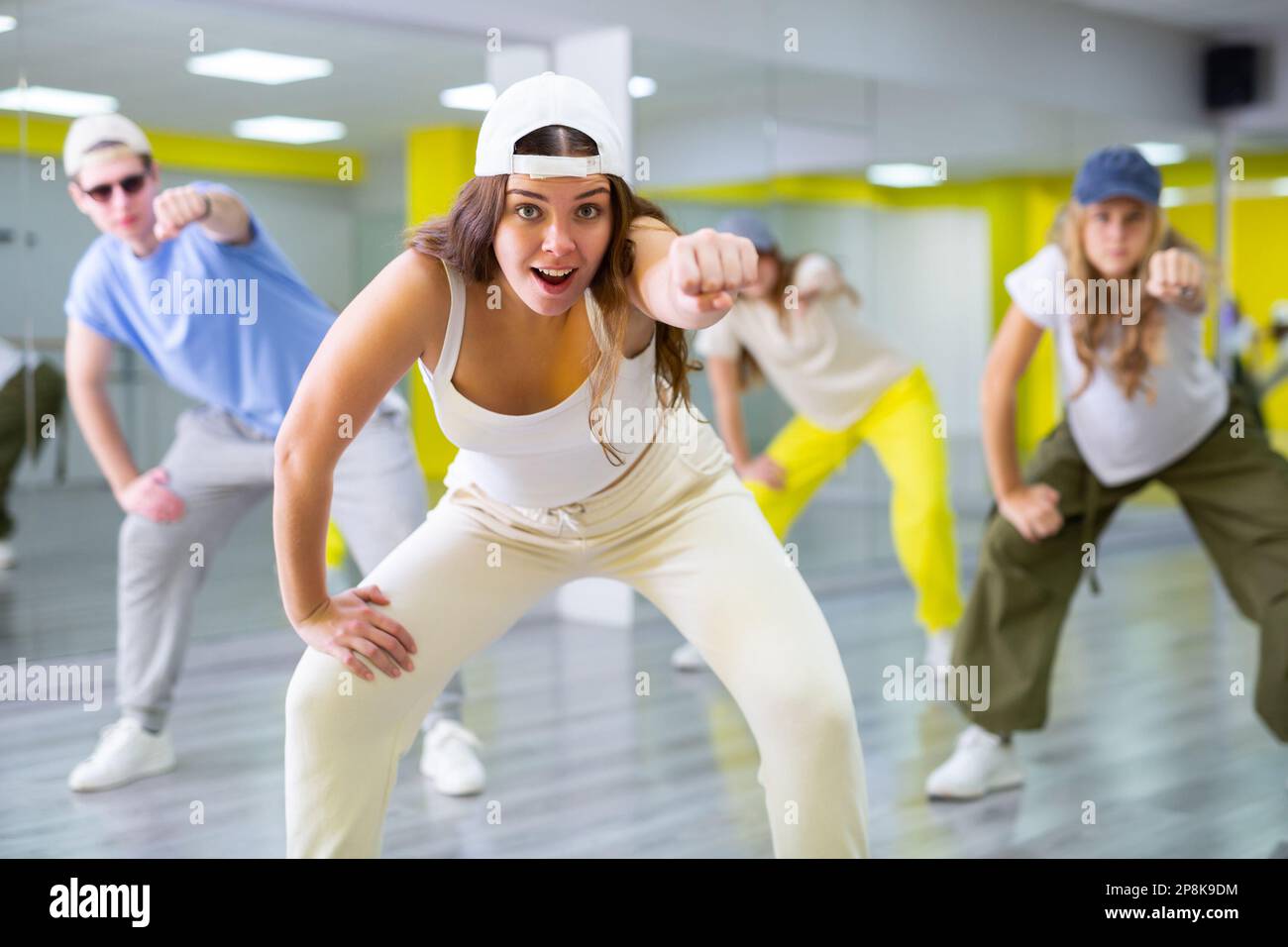 Young girl in cap training breakdance Toprock moves in dance hall Stock ...