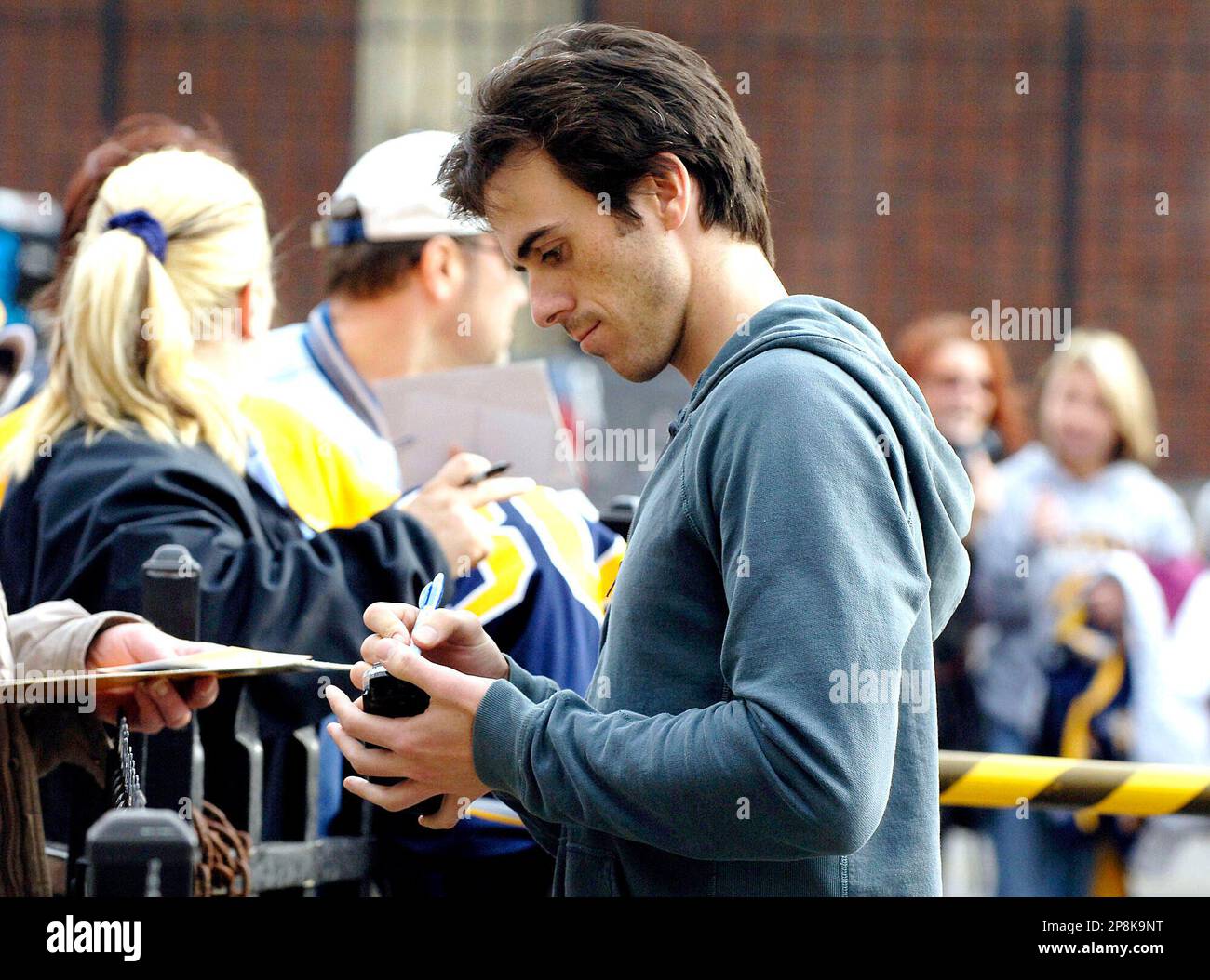 Buffalo Sabres goalie Ryan Miller, center, signs his autograph for fans ...