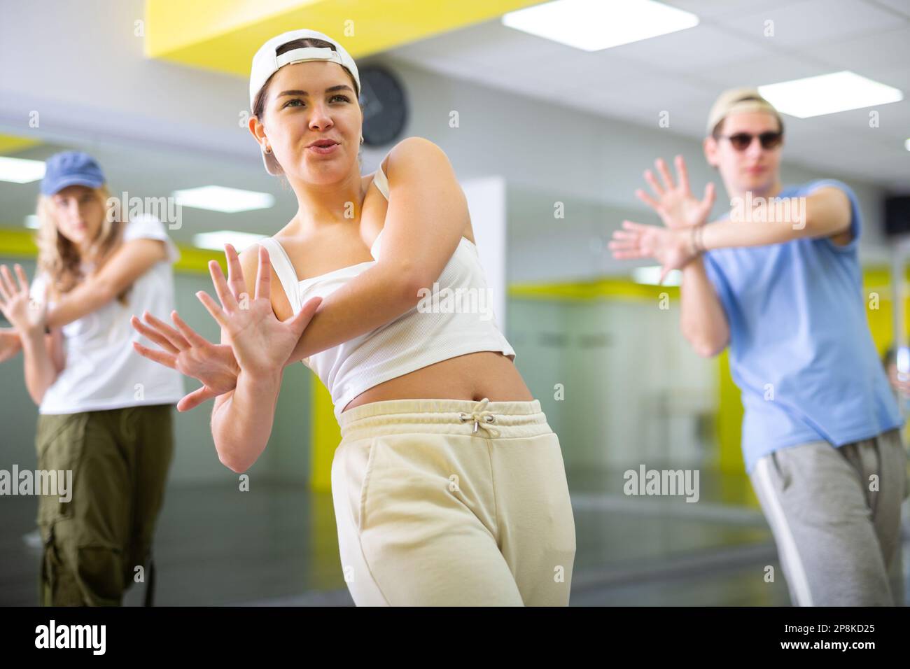 Young girl in cap training breakdance Toprock moves in dance hall Stock ...