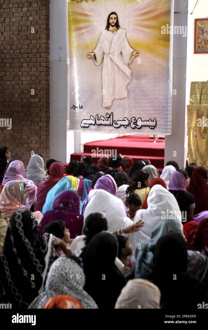 Pakistani Christians pray next to a poster of Jesus Christ during the ...