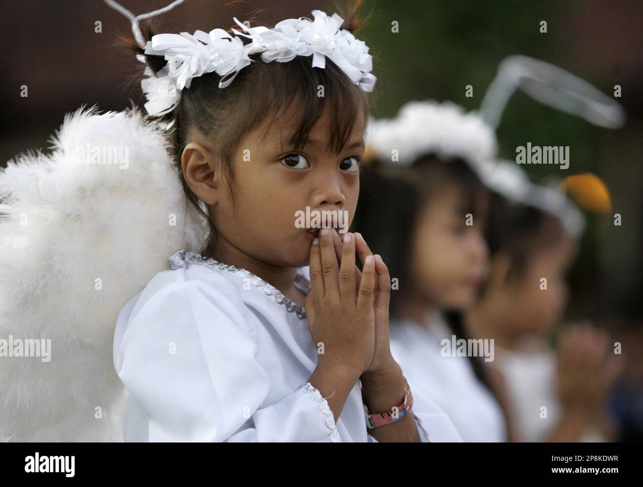 A Filipino girl dressed as an angel joins prayers during Easter rites ...