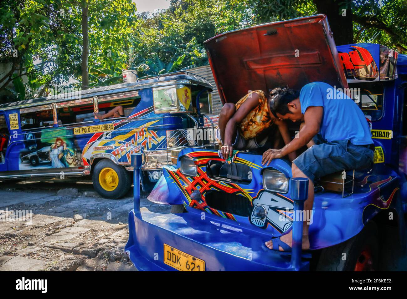 Mechanics fix the engine of a traditional jeepney. For decades ...