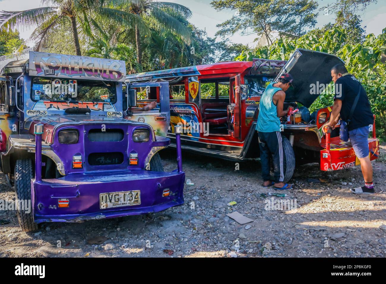 Mechanics fix the engine of a traditional jeepney. For decades ...