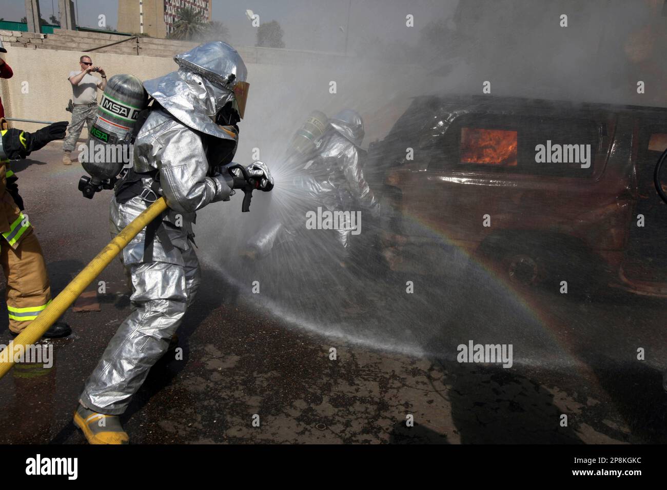 An Iraqi fire fighter works to extinguish a vehicle fire during a ...