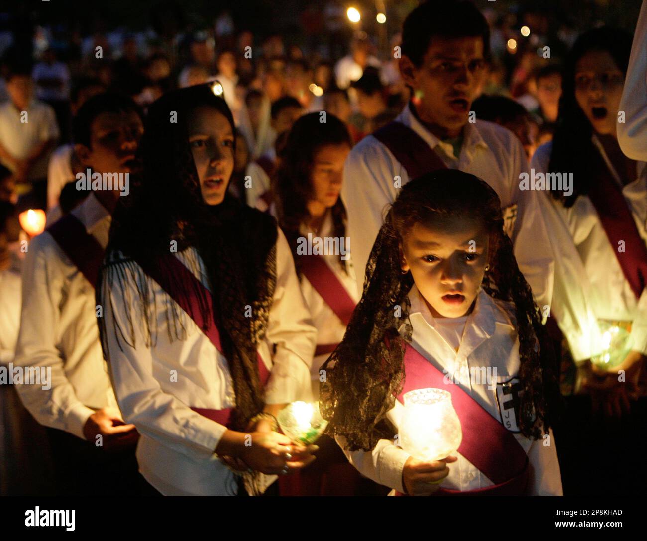 Carrying candles, members of a Paraguayan musical group of faithful ...