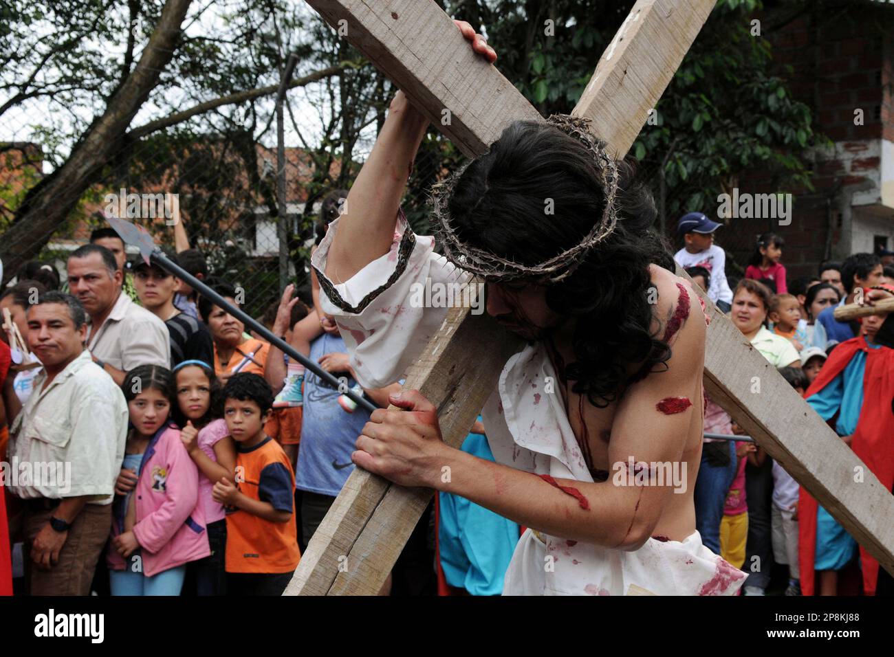 A man dressed as Jesus Christ carries a cross as he reenacts Jesus ...