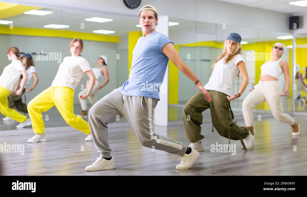 Emotional teen boy dancing with group of friends in dance studio. Hip ...