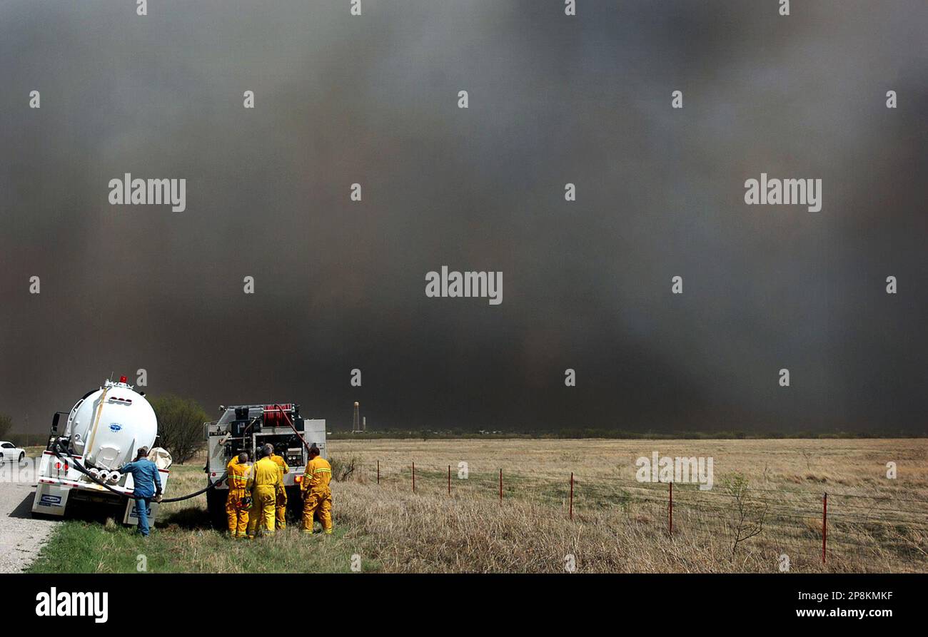 Heavy smoke fills the sky as a massive wildfire approaches the west ...