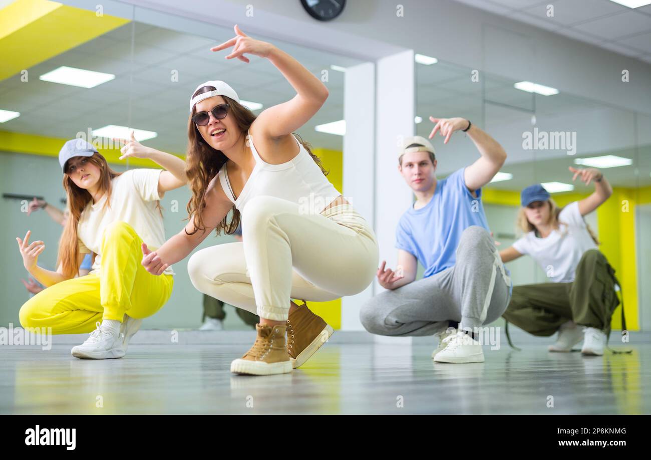 Young girl sitting in breakdance pose in dance hall Stock Photo - Alamy