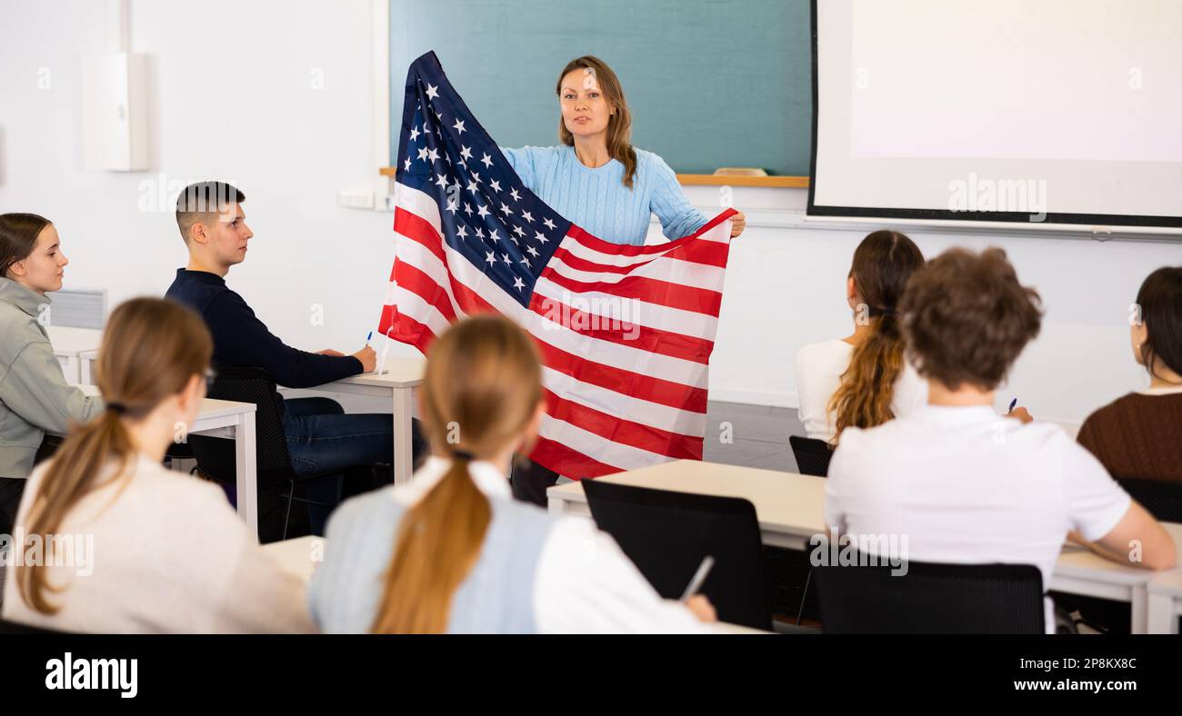 Female professor shows students flag of USA Stock Photo - Alamy