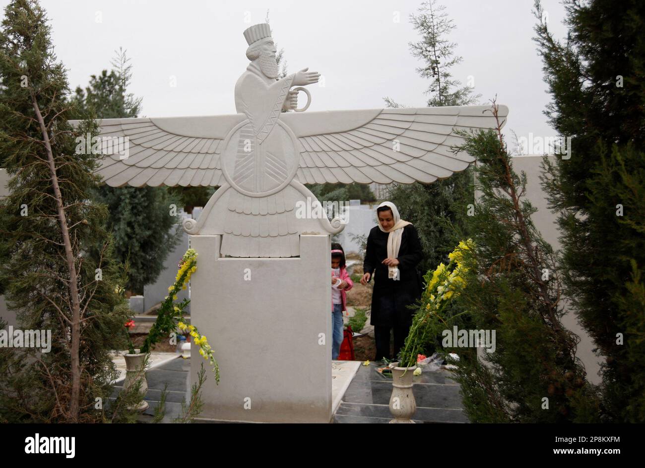 infront of a statue of Zoroaster an Iranian Zoroastrian woman with her ...