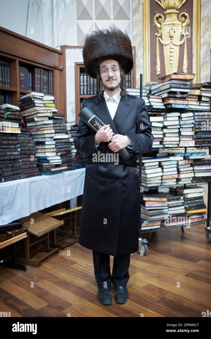 Posed portrait of an orthodox Jewish man wearing a streimel and holding ...