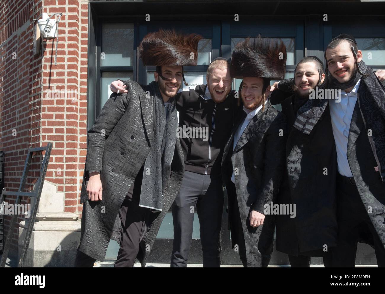 A group of 5 orthodox Hasidic Jews pose for a joyous photo on Purim. In ...