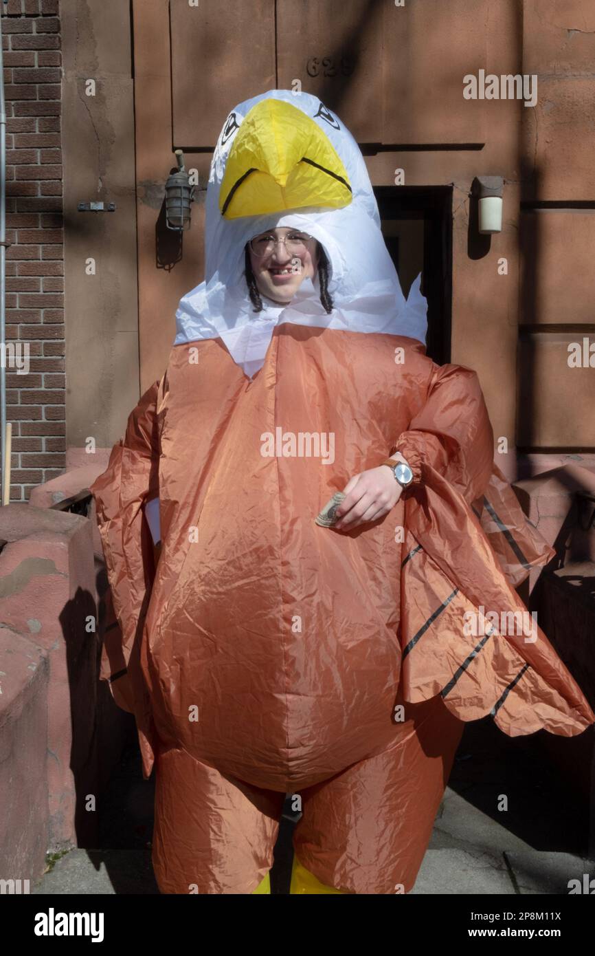 A teenage Hasidic Jewish boy dressed for Purim in an inflatable Eagle ...