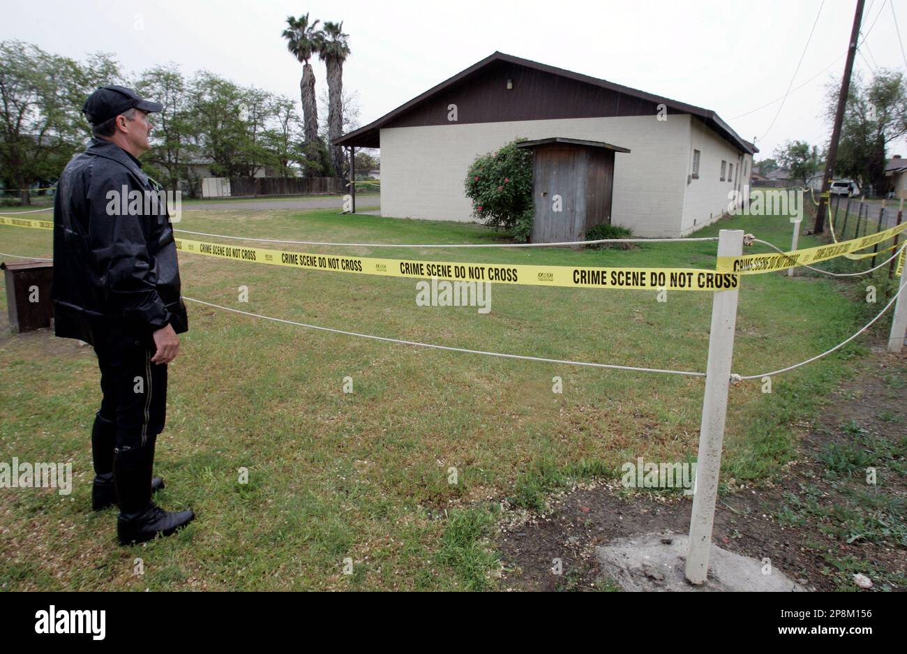 A Tracy police officer stands guard as police tape surround Clover Road ...