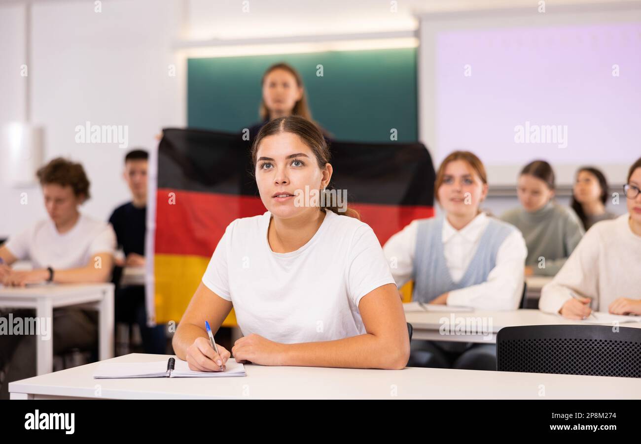 Teacher stands behind students with German flag Stock Photo - Alamy
