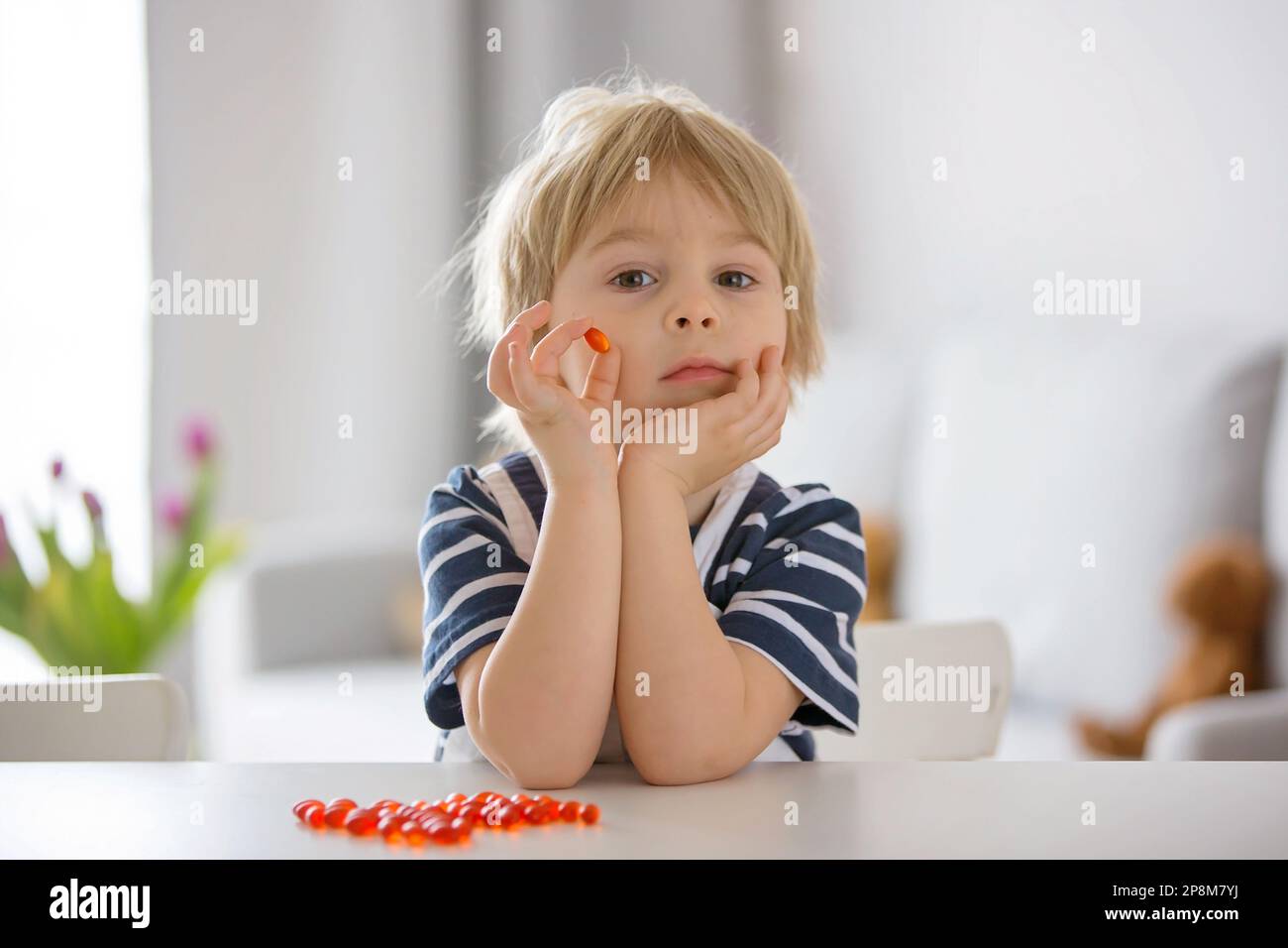 Cute little child, toddler boy, eating alfa omega 3 child supplement ...