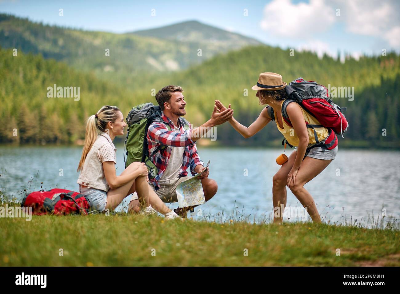 young adult couple meeting a female friend in the nature. active ...