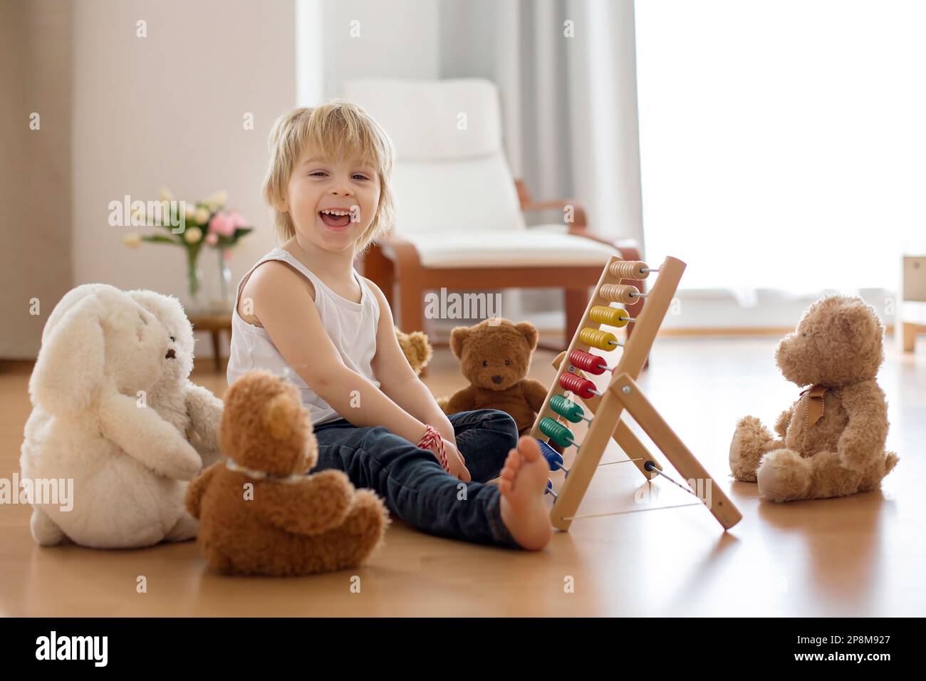 Sweet blond preschool child, toddler boy, playing with abacus at home ...