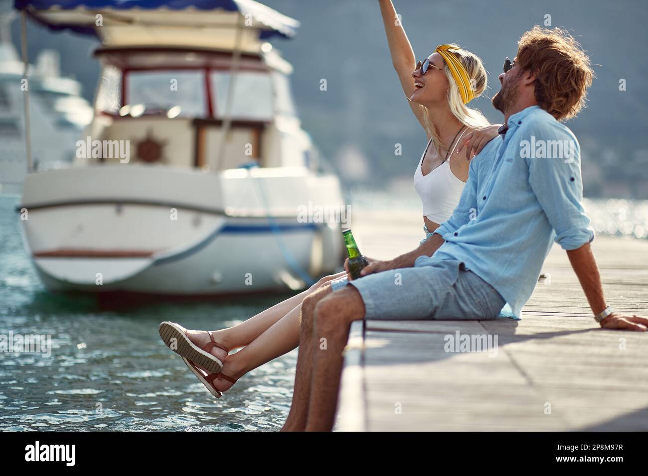 adult caucasian couple sitting on a dock, talking, smiling, laughing ...