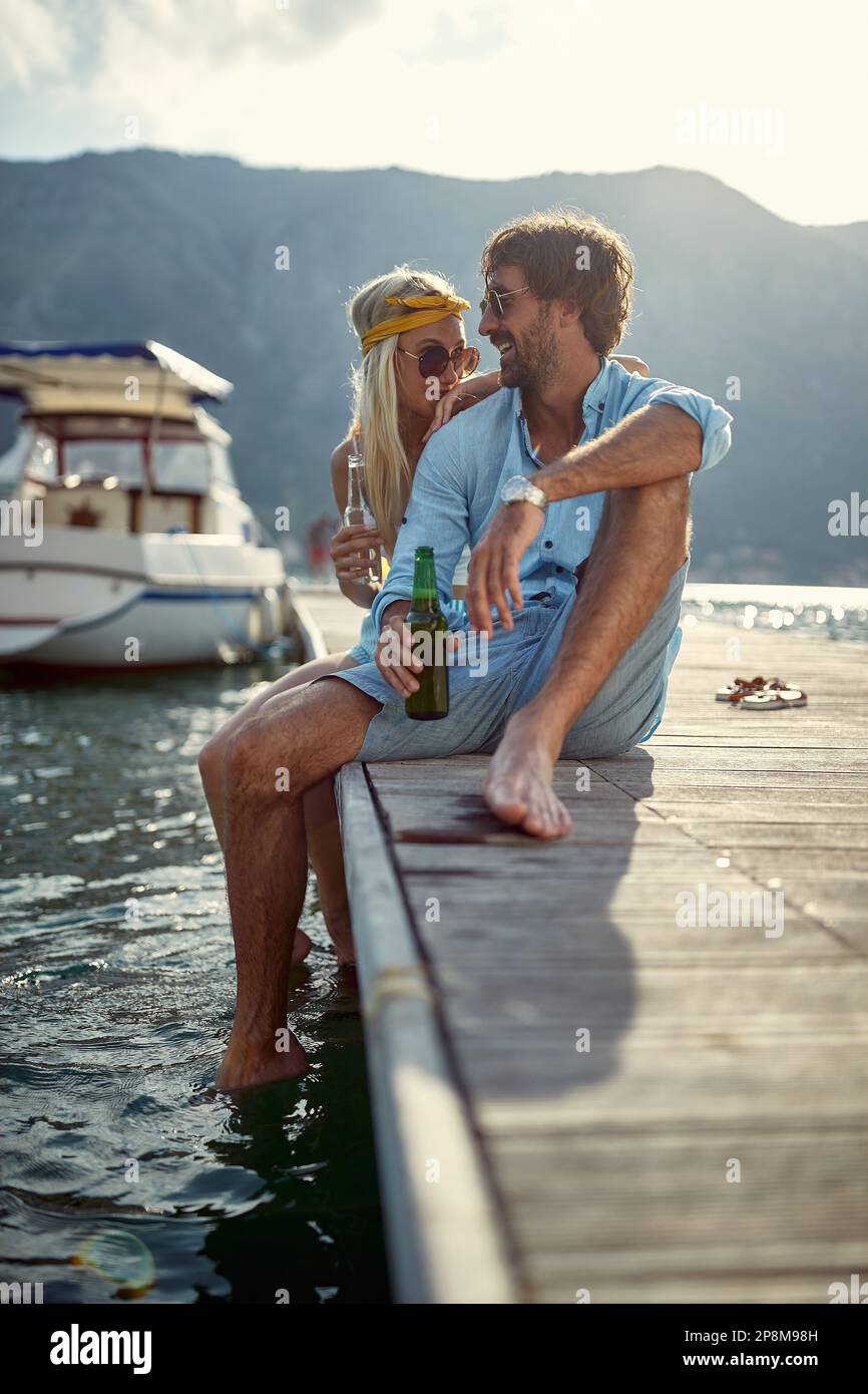 adult caucasian couple sitting on a dock, talking, smiling, laughing ...