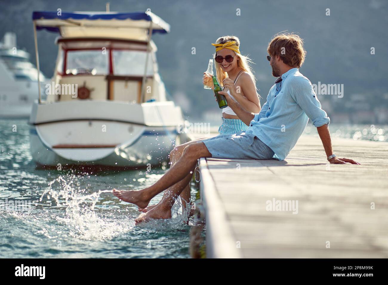 adult caucasian couple sitting on a dock, talking, smiling, laughing ...